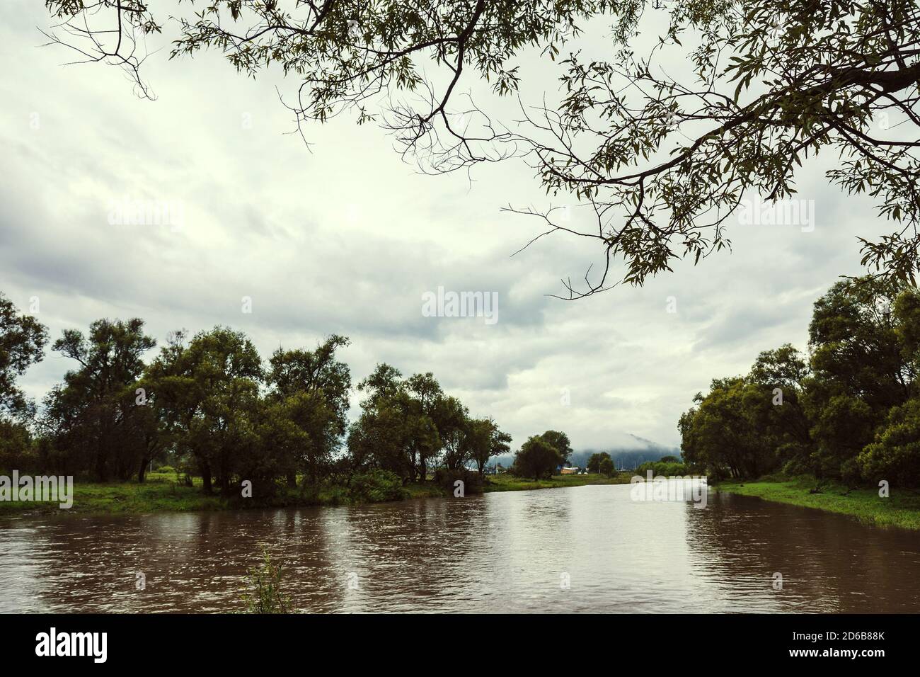 A dirty river flows in a rural mountainous area. Bad weather Stock ...