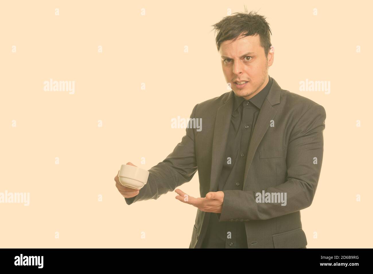 Studio shot of angry Caucasian businessman holding coffee cup Stock ...