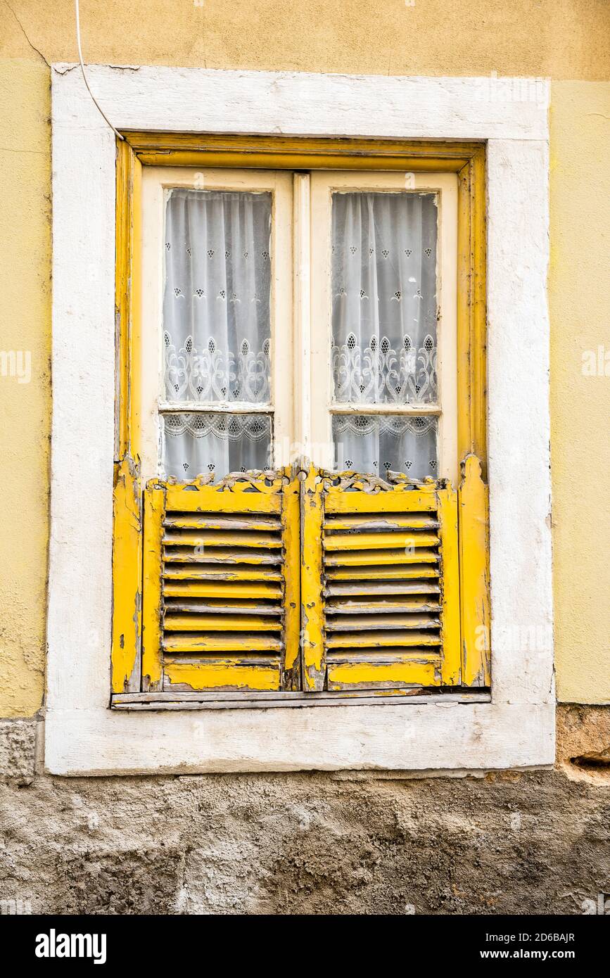 Window of the house with dilapidated shutters on the street in Lisbon ...