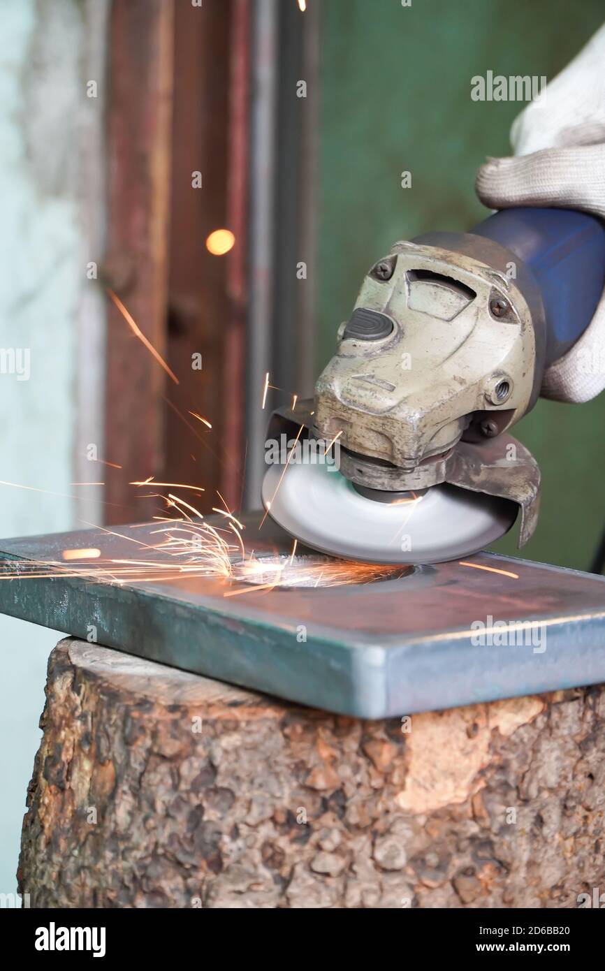Worker with Angle Grinder does Metalworking in Industrial Environment ...