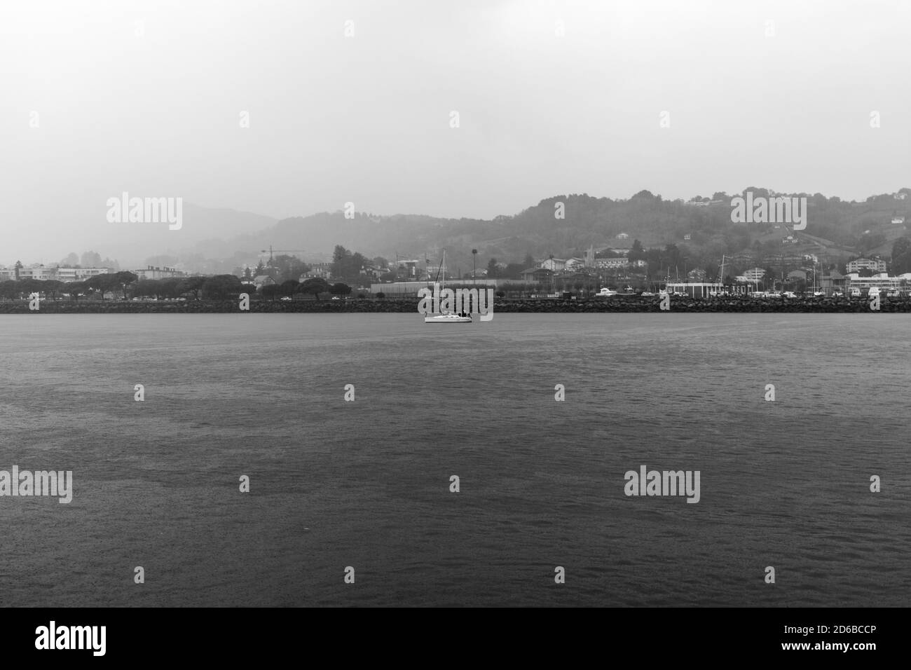 Sailboat returning to port under heavy rain Stock Photo - Alamy