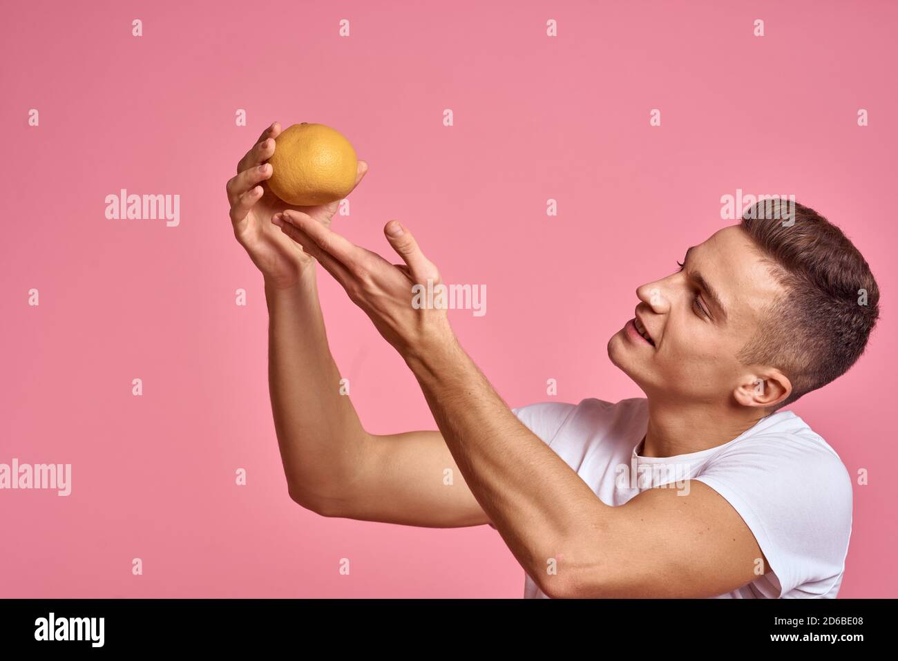 Man with fruits in hands on a pink background healthy food vitamins ...