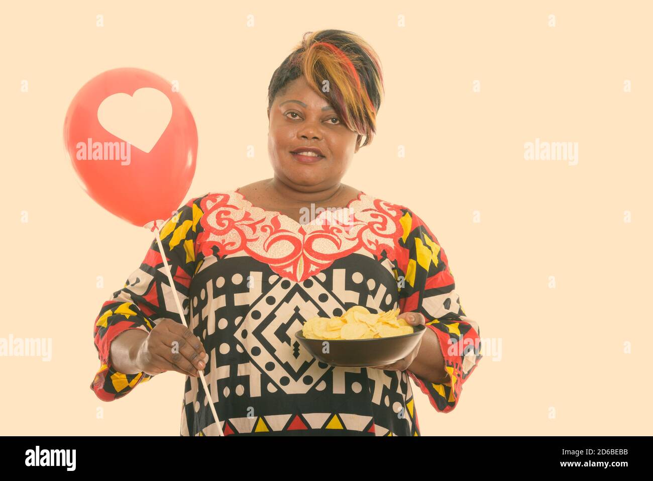 Thoughtful happy fat black African woman smiling while holding bowl of ...