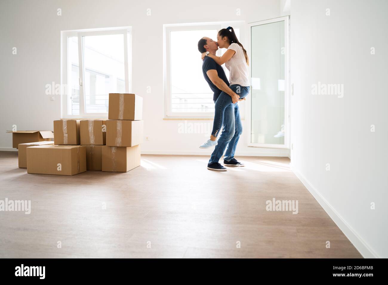 Couple Making Jump And Hug While Moving Boxes Stock Photo - Alamy