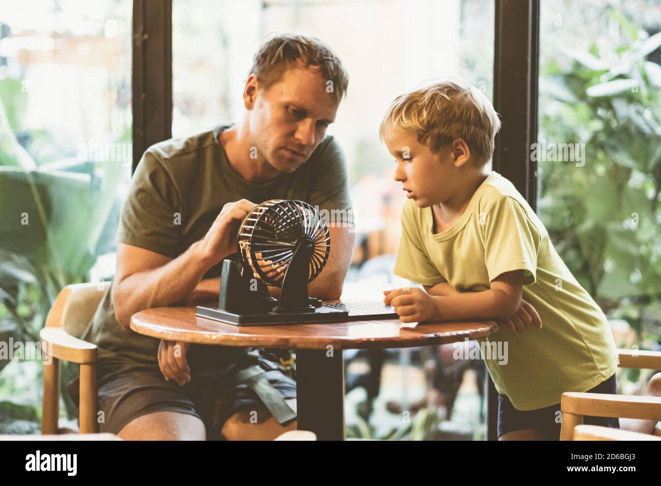 Father blond son boy play lotto, round sphere spins with small orange ...