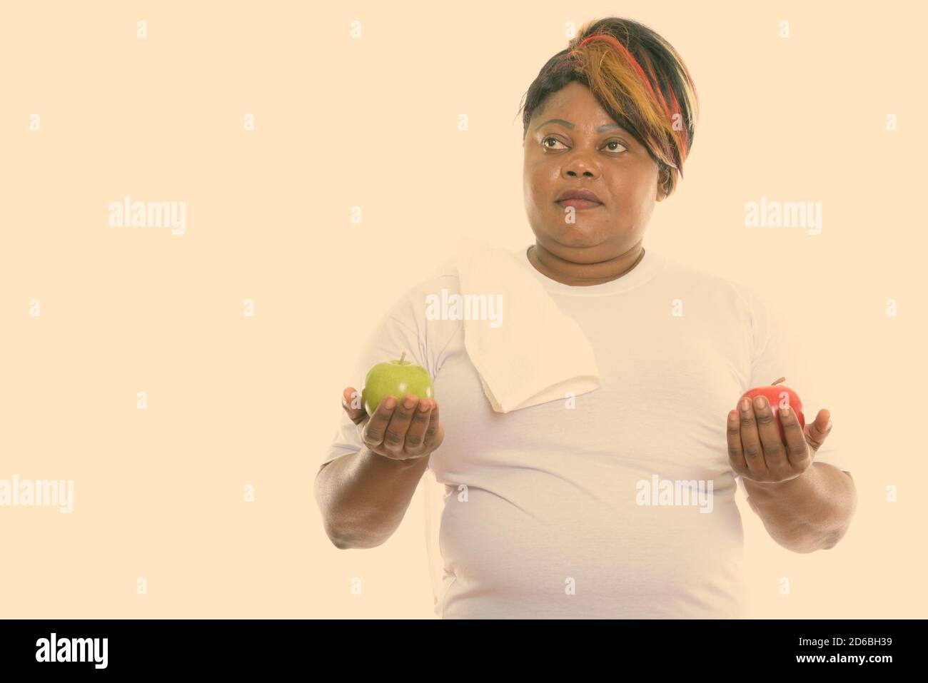 Studio shot of fat black African woman thinking while holding green ...