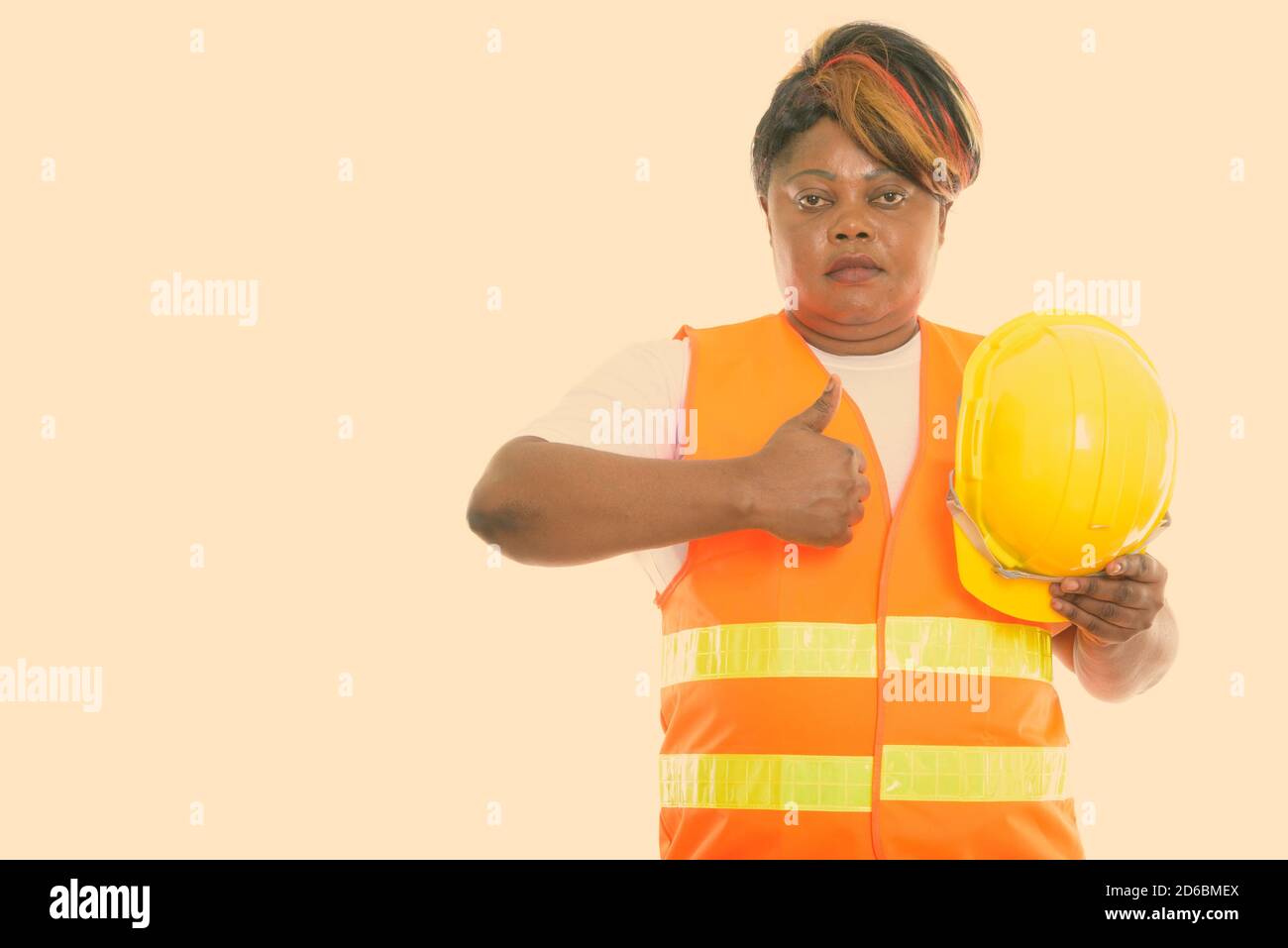 Studio shot of fat black African woman construction worker holding ...