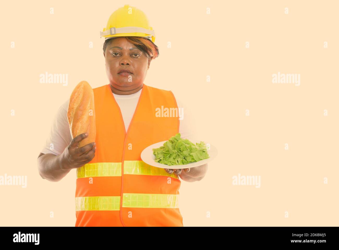 Studio shot of fat black African woman construction worker holding ...