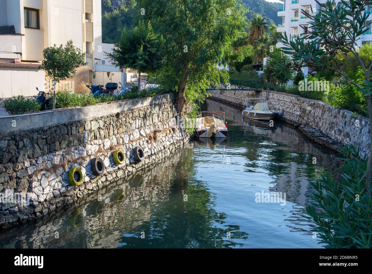 Small water canal in Turkish city. City landscape with canal, boats and ...