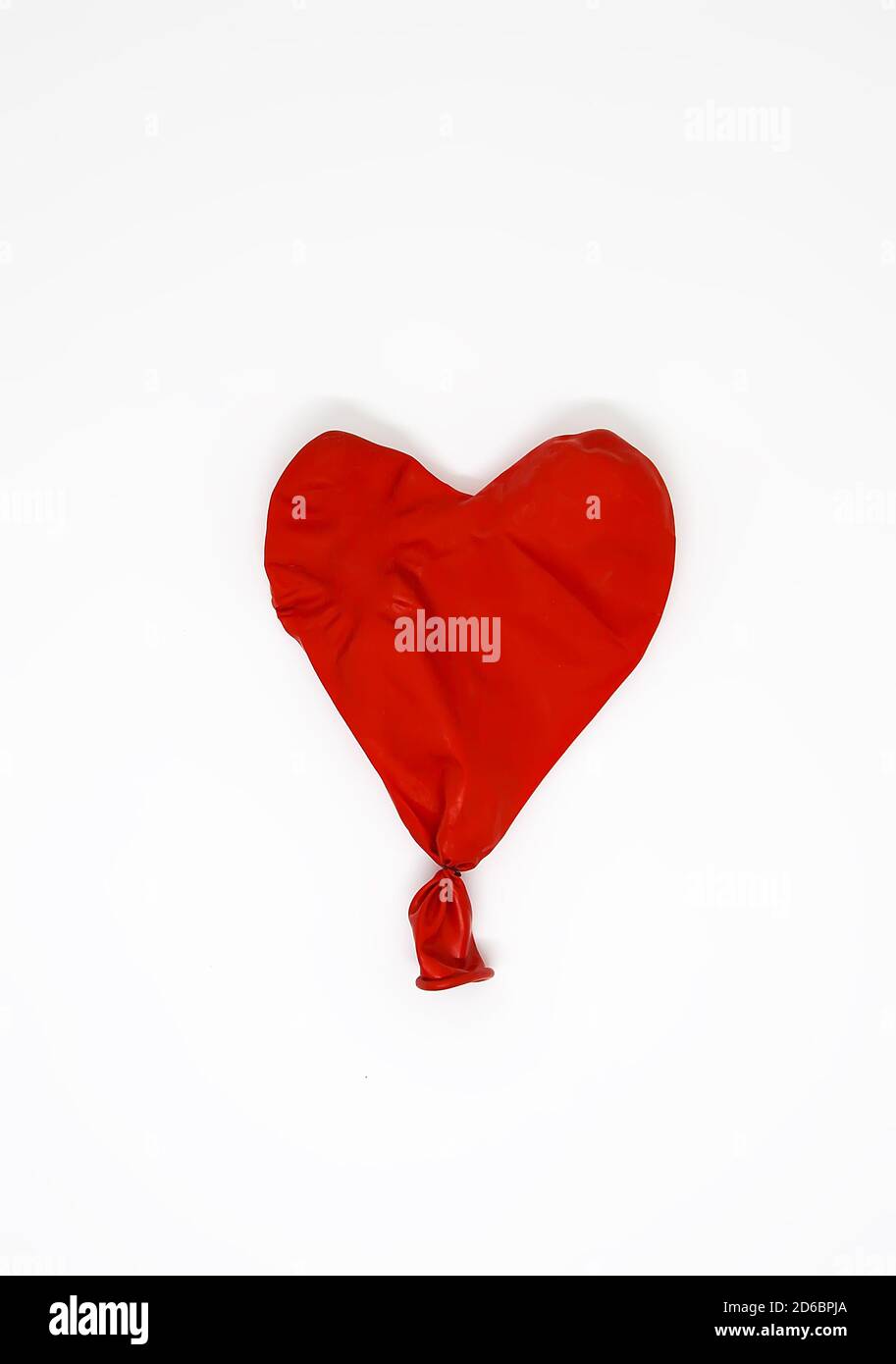 Red heart deflated balloon on white background Stock Photo - Alamy