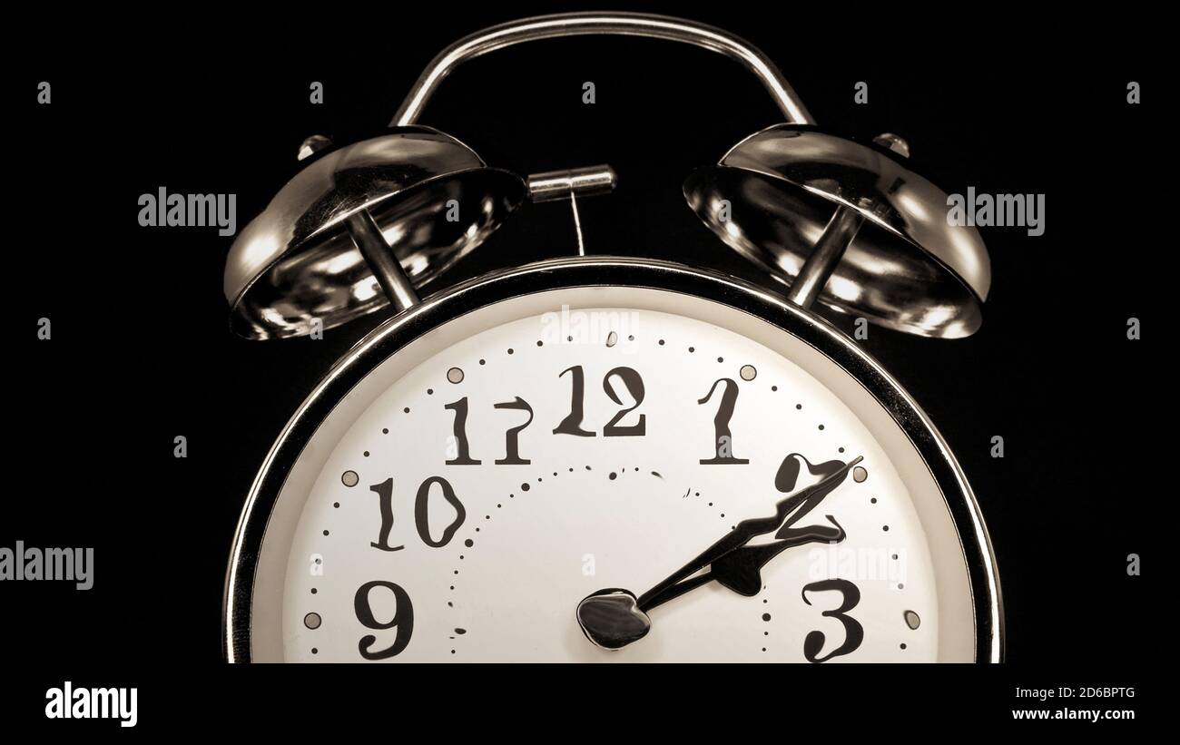 retro alarm clock distorted and melting isolated on a black background ...