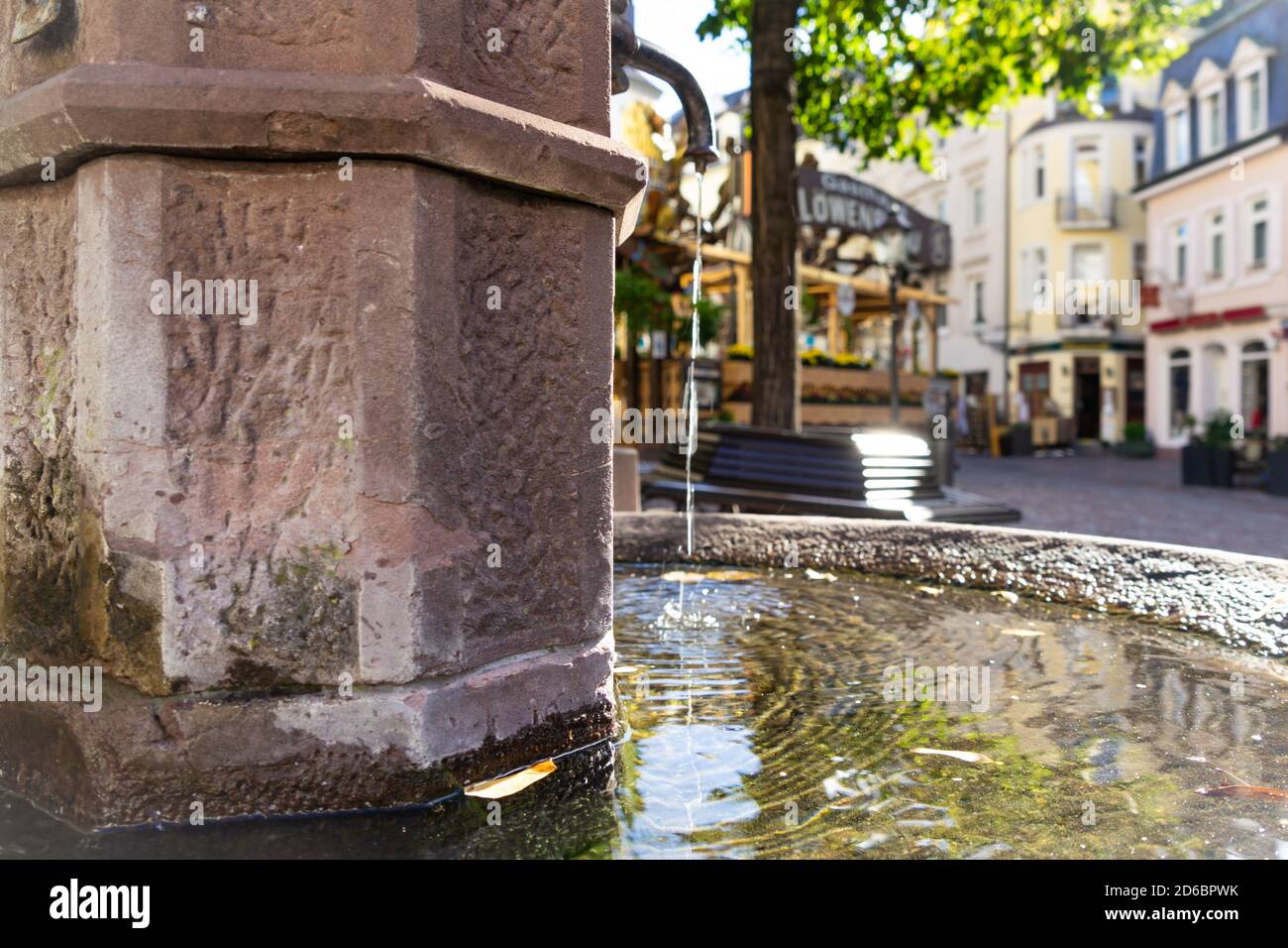 A historical fountain with water running from the tap overlooks a part ...