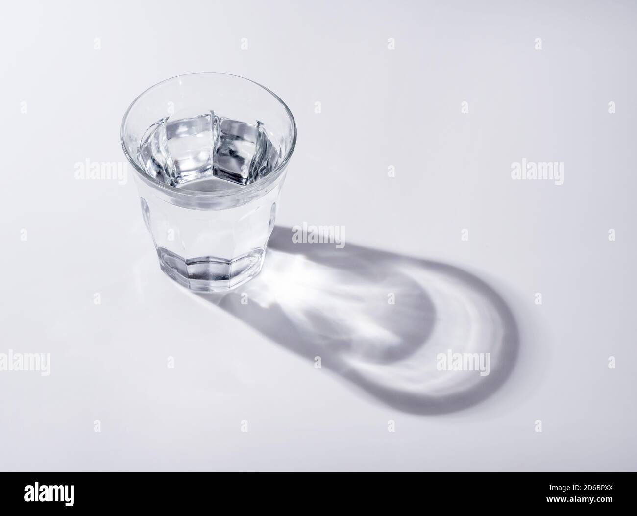 A clear glass of water and its shadow on a white background Stock Photo ...