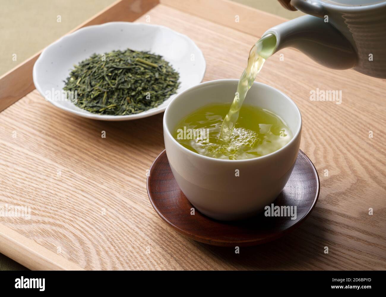 Pouring green tea into a teacup. Japanese green tea image Stock Photo ...