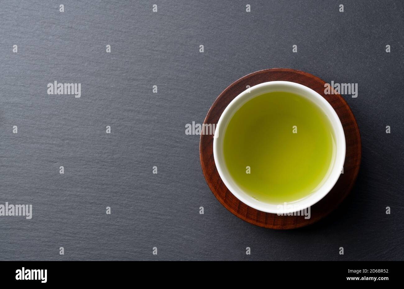 A bird's-eye view of green tea placed on a black background with space ...
