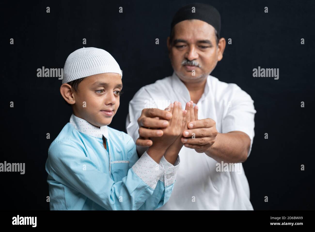 Muslim Father teaching his son how to do Salah or payer in a Islamic ...