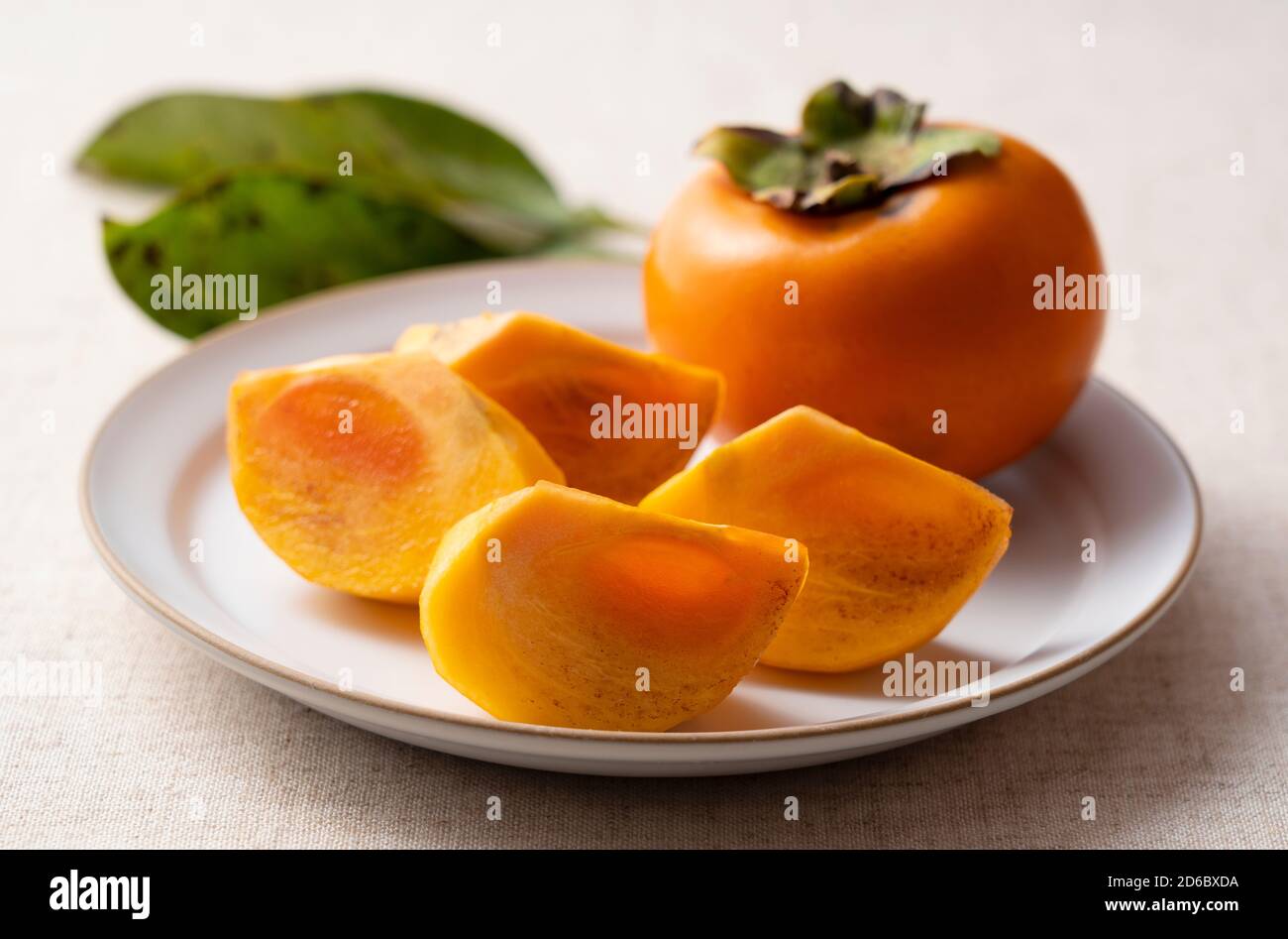 Cut Japanese persimmons on a plate. Japanese style image Stock Photo ...