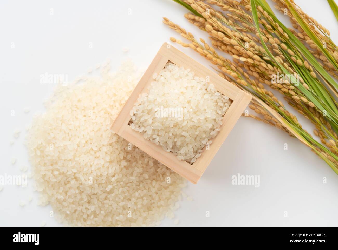 A bird's-eye view of white rice, measuring cups and ears of rice on a ...