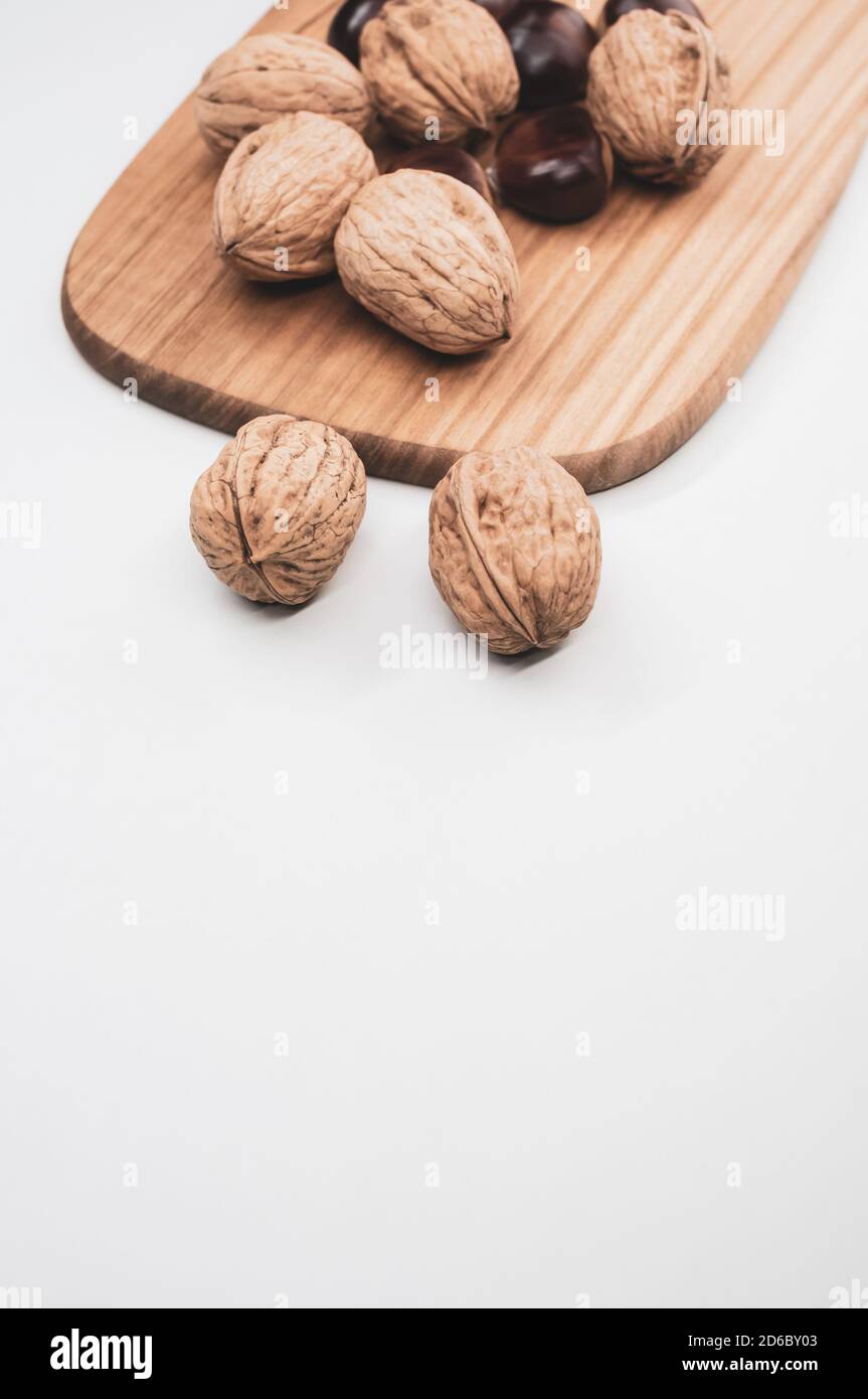 Shot of chestnuts and walnuts on a wooden board Stock Photo - Alamy