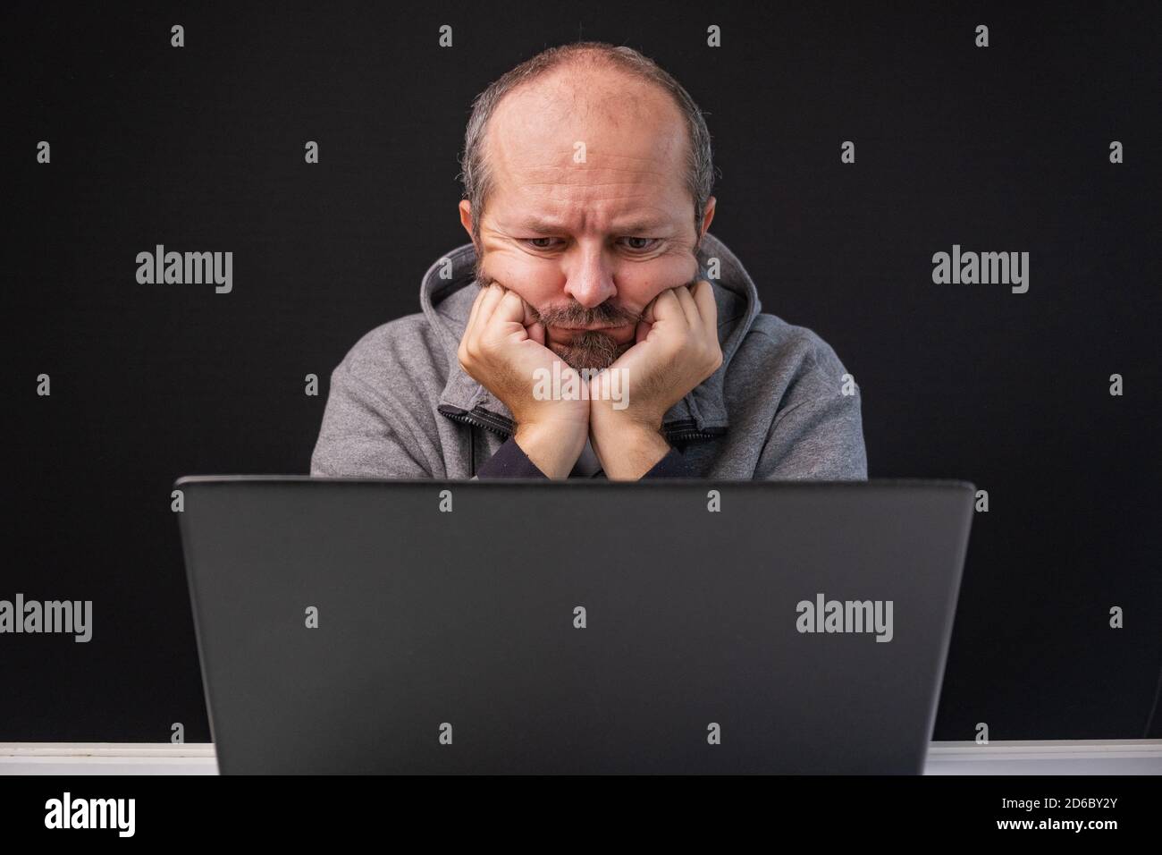 Worried man in hoodie working from home office. Adult bearded man ...