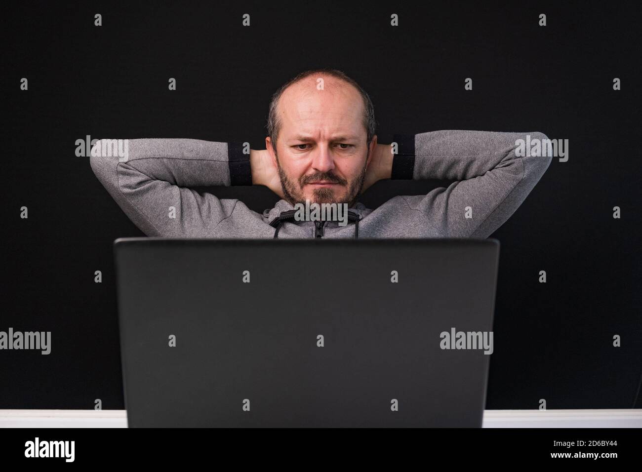 Caucasian adult man sitting behind the laptop and trying to solve a ...