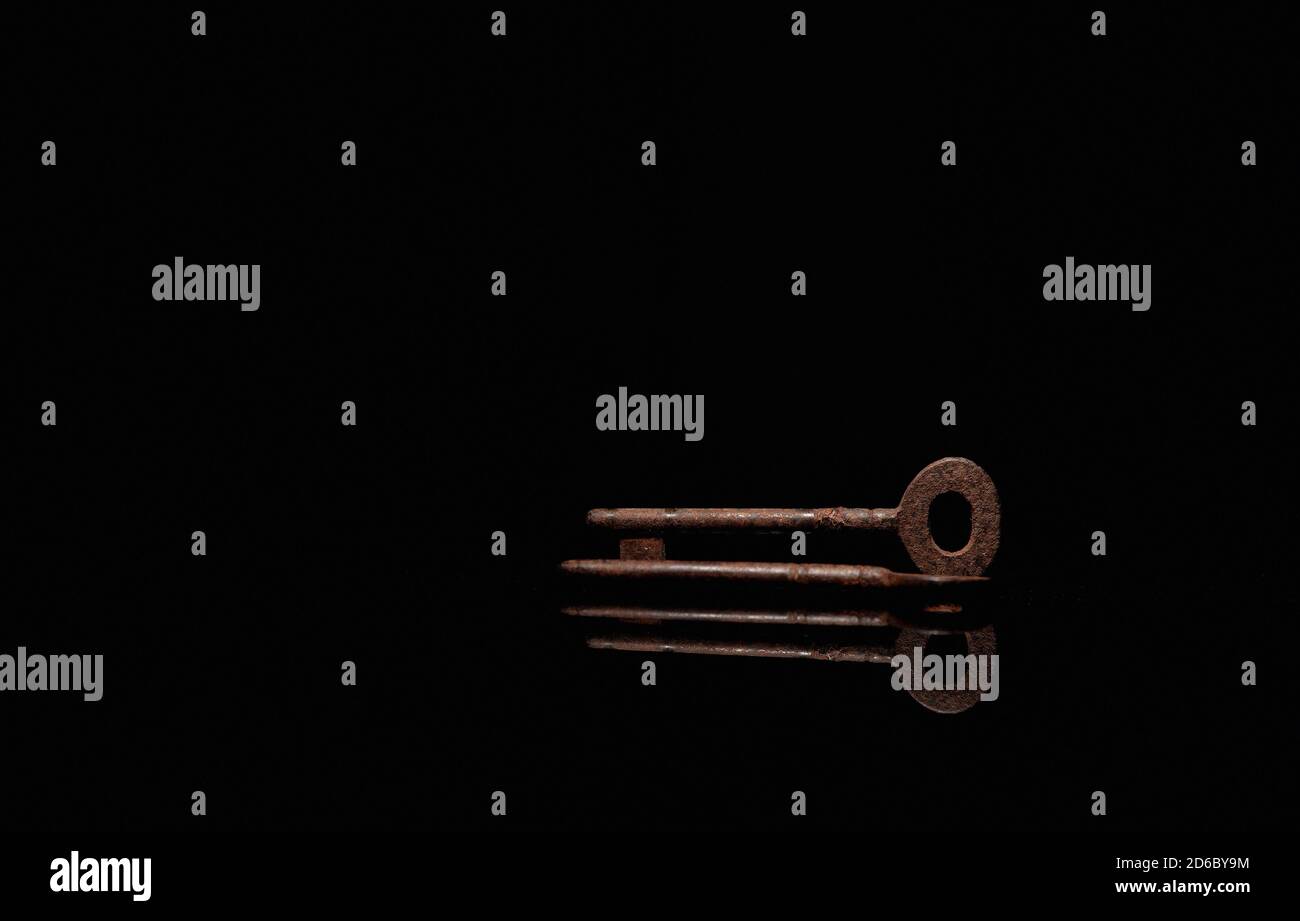 antique rusted chest key in dark black background with reflection on ...
