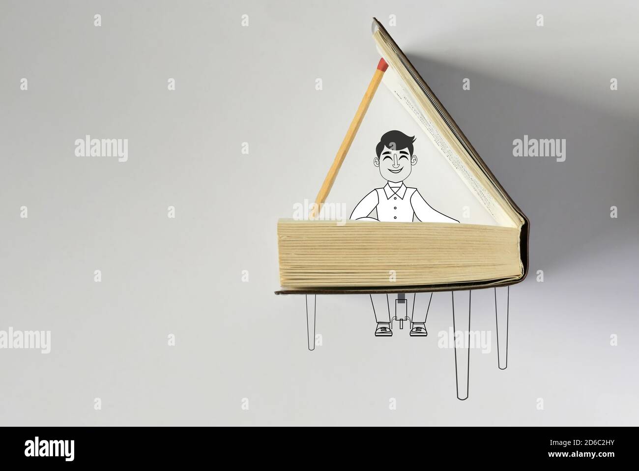 Concept Of Man Playing Piano on Open Book Stock Photo - Alamy