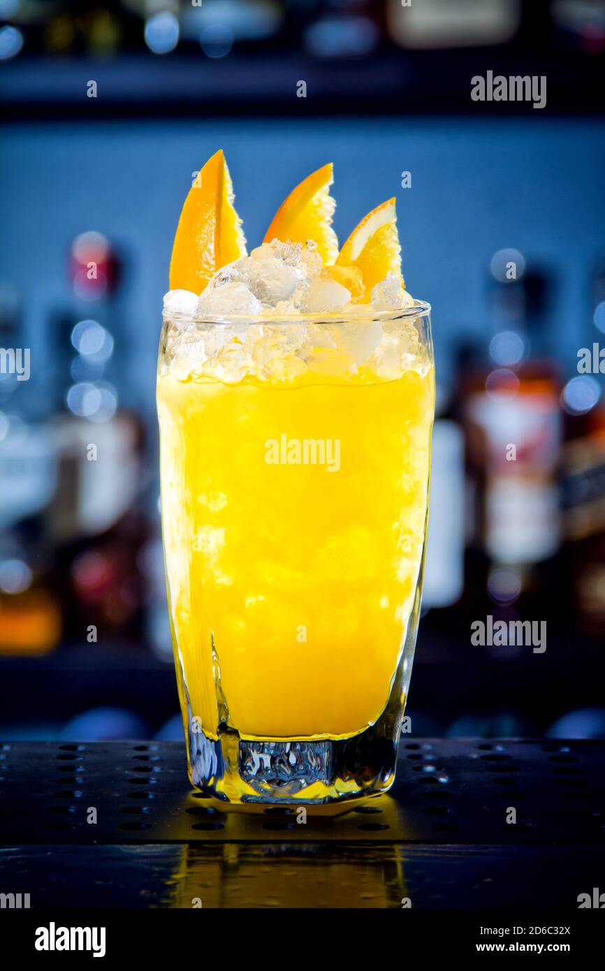 Yellow drink cocktail with orange slices at the bar counter Stock Photo ...