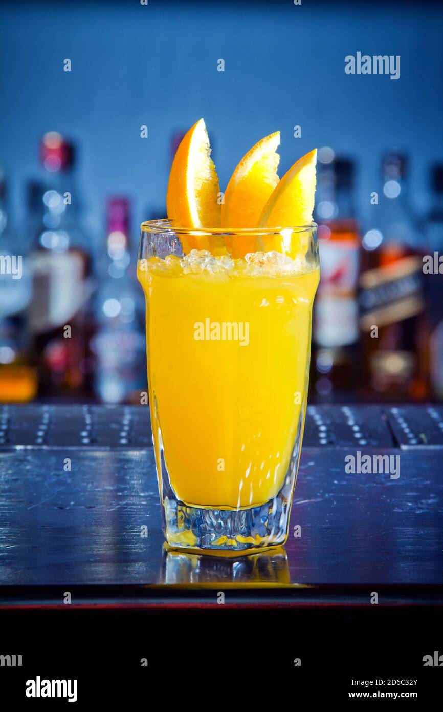 Yellow drink cocktail with orange slices at the bar counter Stock Photo ...