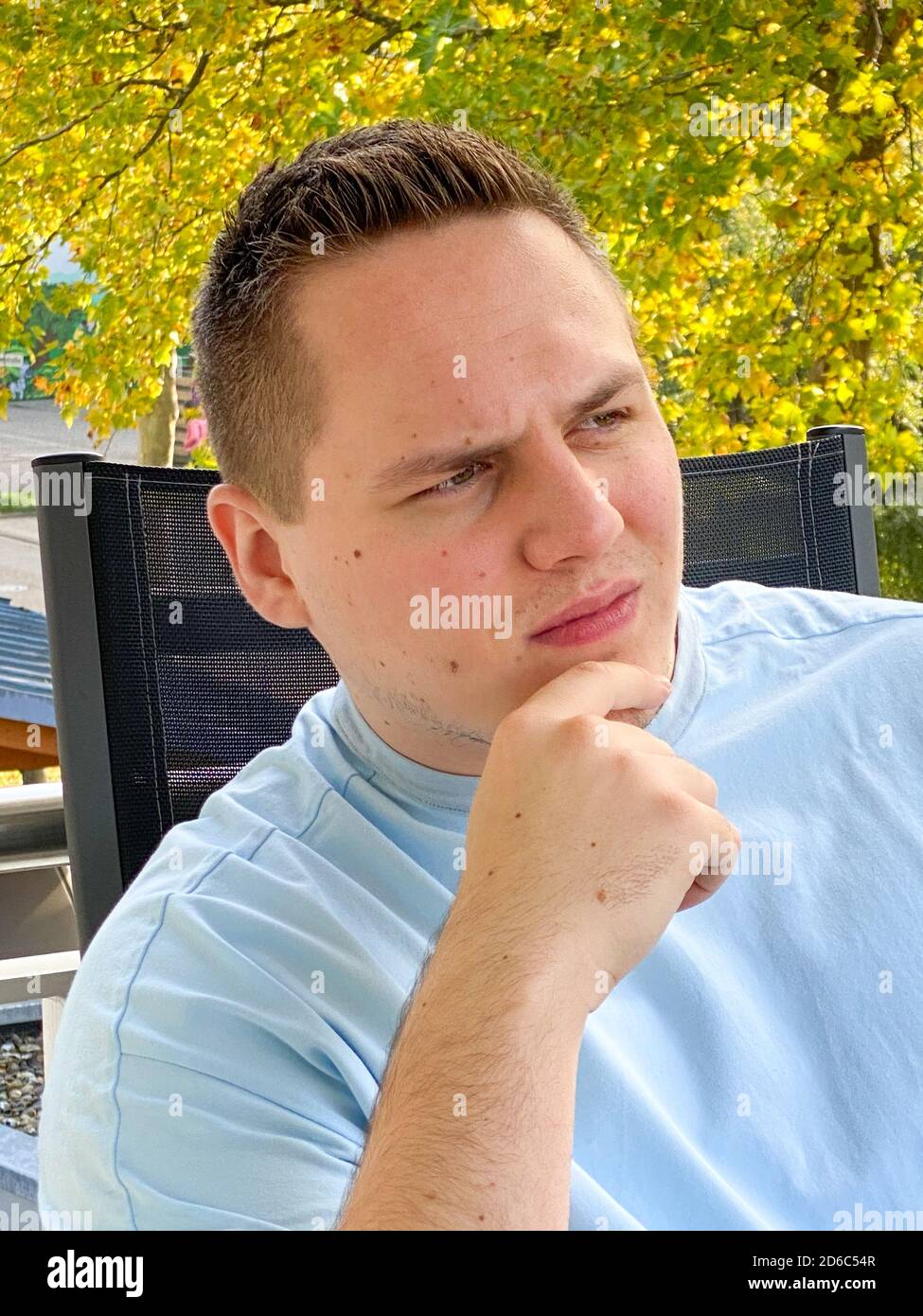 Concerned young man staring intently at the camera with a quiet frown ...