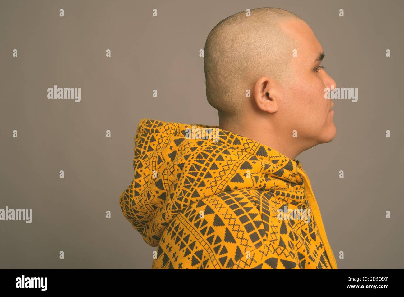 Young bald Asian man against gray background Stock Photo - Alamy
