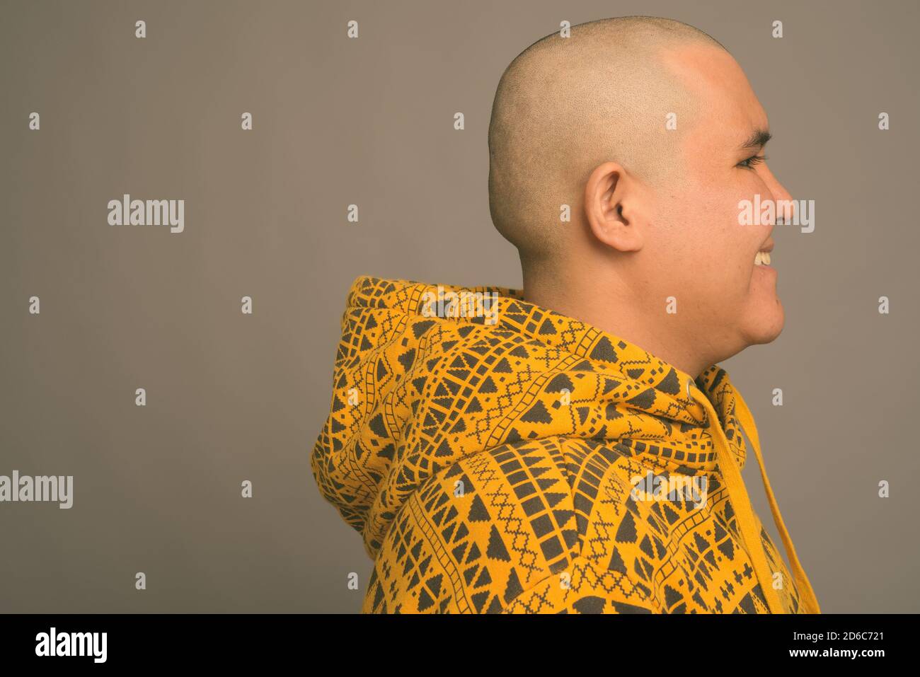 Young bald Asian man against gray background Stock Photo - Alamy
