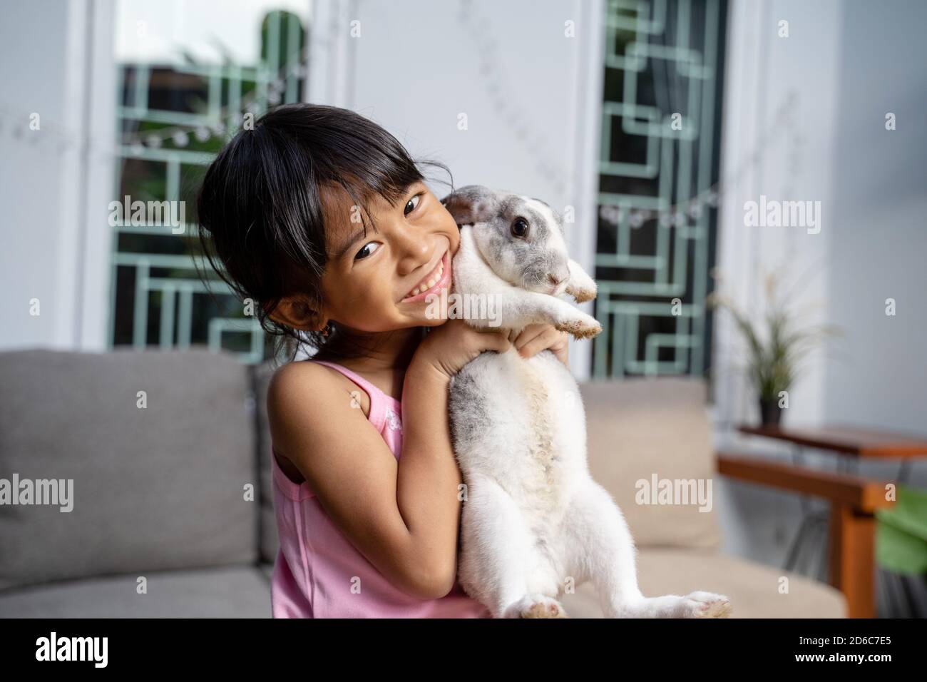 smile little girl and white rabbit, playing at home Stock Photo - Alamy