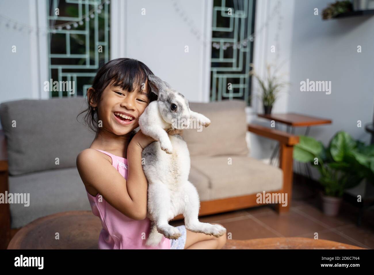 smile little girl and white rabbit, playing at home Stock Photo - Alamy