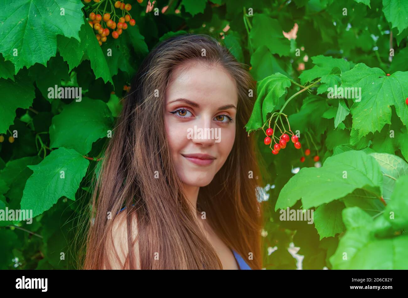 Attractive woman with long hair looks into the camera with half turn on ...