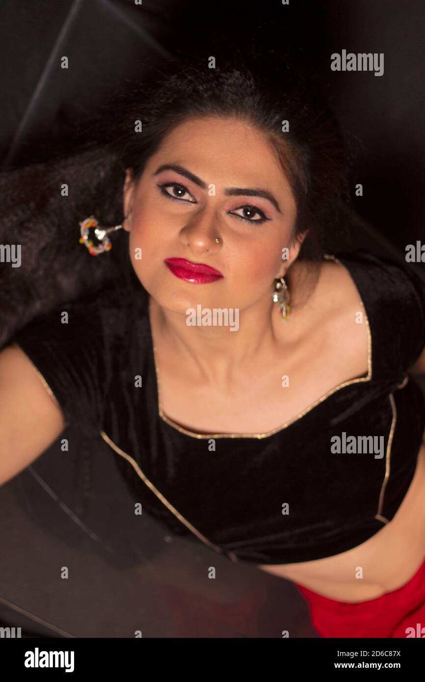 Young Indian female model lying down looking straight at camera Black ...