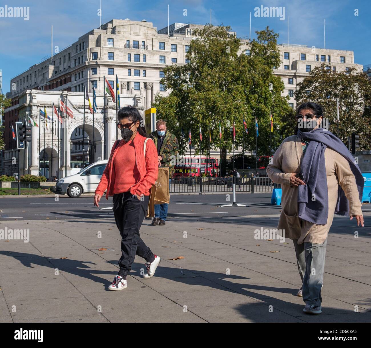 Two women wearing face masks walk past Marble Arch, London, towards ...
