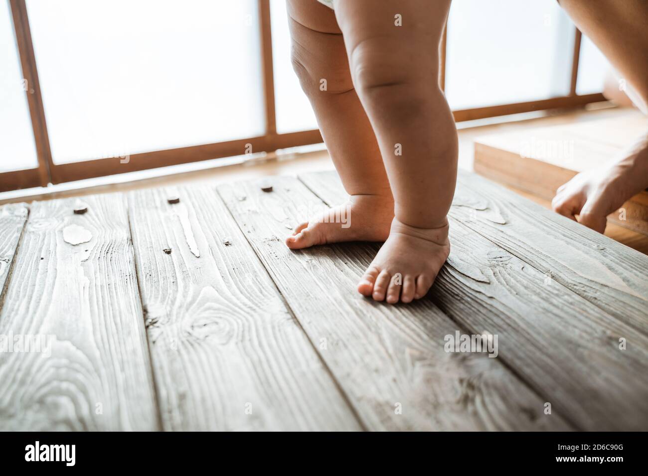 close up of baby feet doing the first steps on wooden floor Stock Photo ...