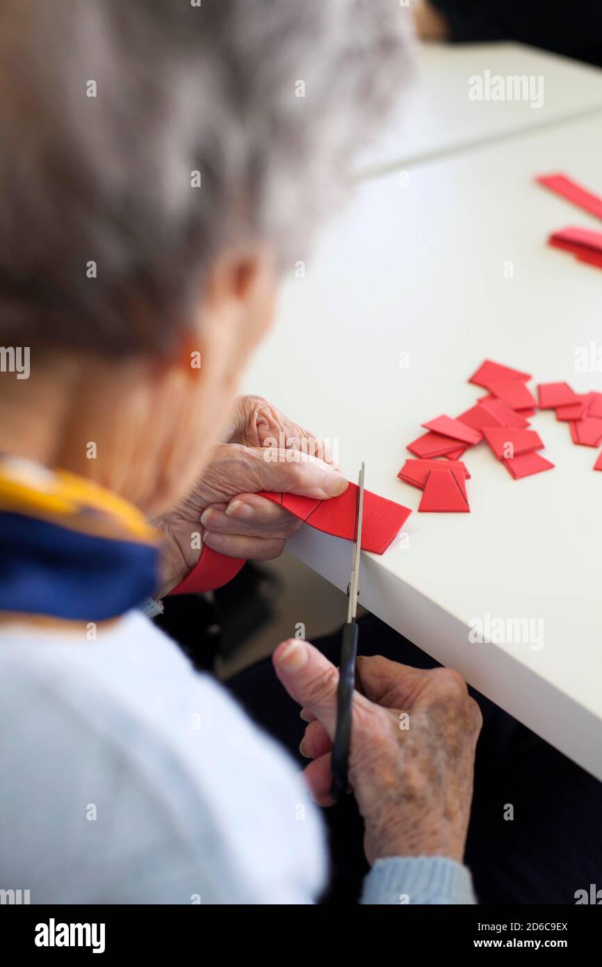 Senior woman cutting paper for a plant vase Stock Photo - Alamy