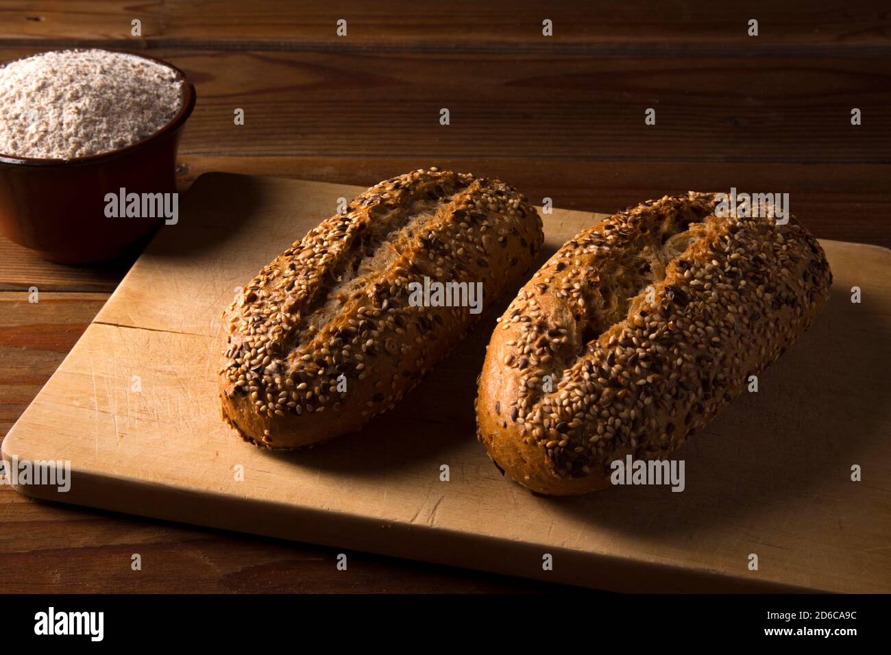 multigrain wholemeal bread with seeds on brown wooden table Stock Photo ...