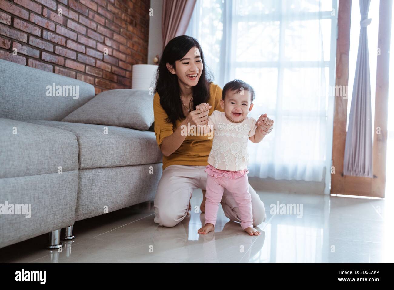 baby first step walking. mother help her baby to walk her first step at ...
