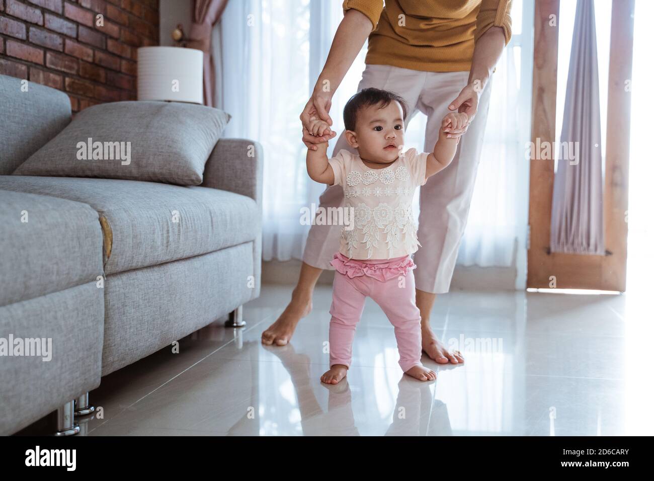 baby first step walking. mother help her baby to walk her first step at ...
