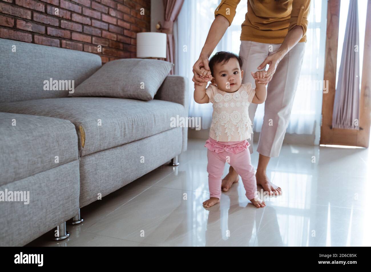 baby first step walking. mother help her baby to walk her first step at ...