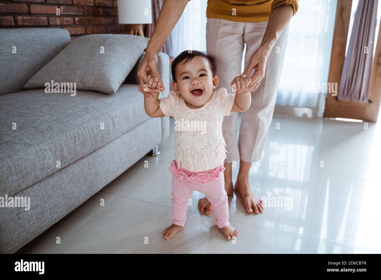 baby first step walking. mother help her baby to walk her first step at ...