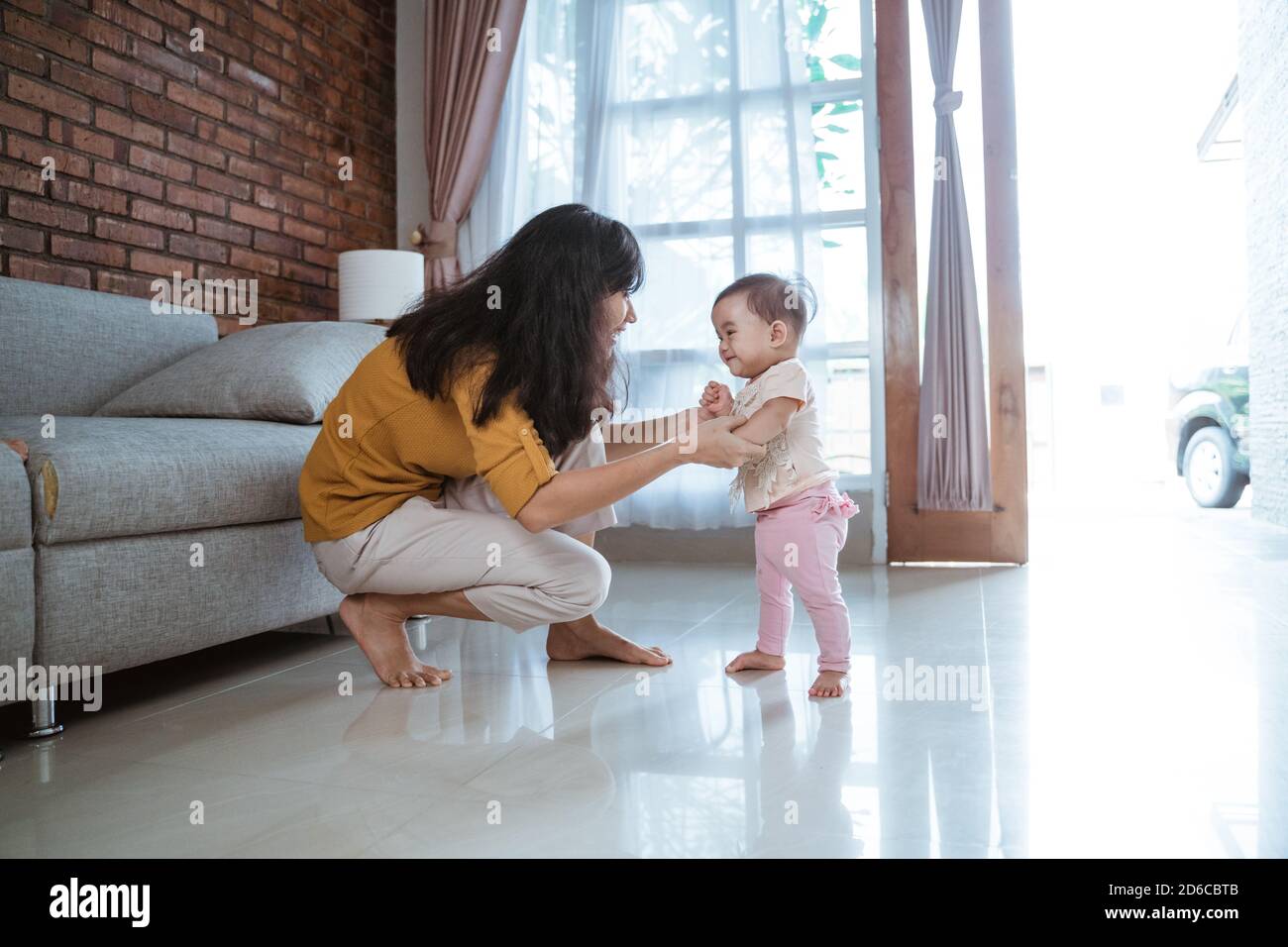 baby first step walking. mother help her baby to walk her first step at ...