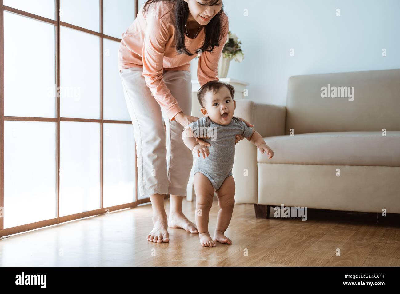 baby first step walking. mother help her baby to walk her first step at ...