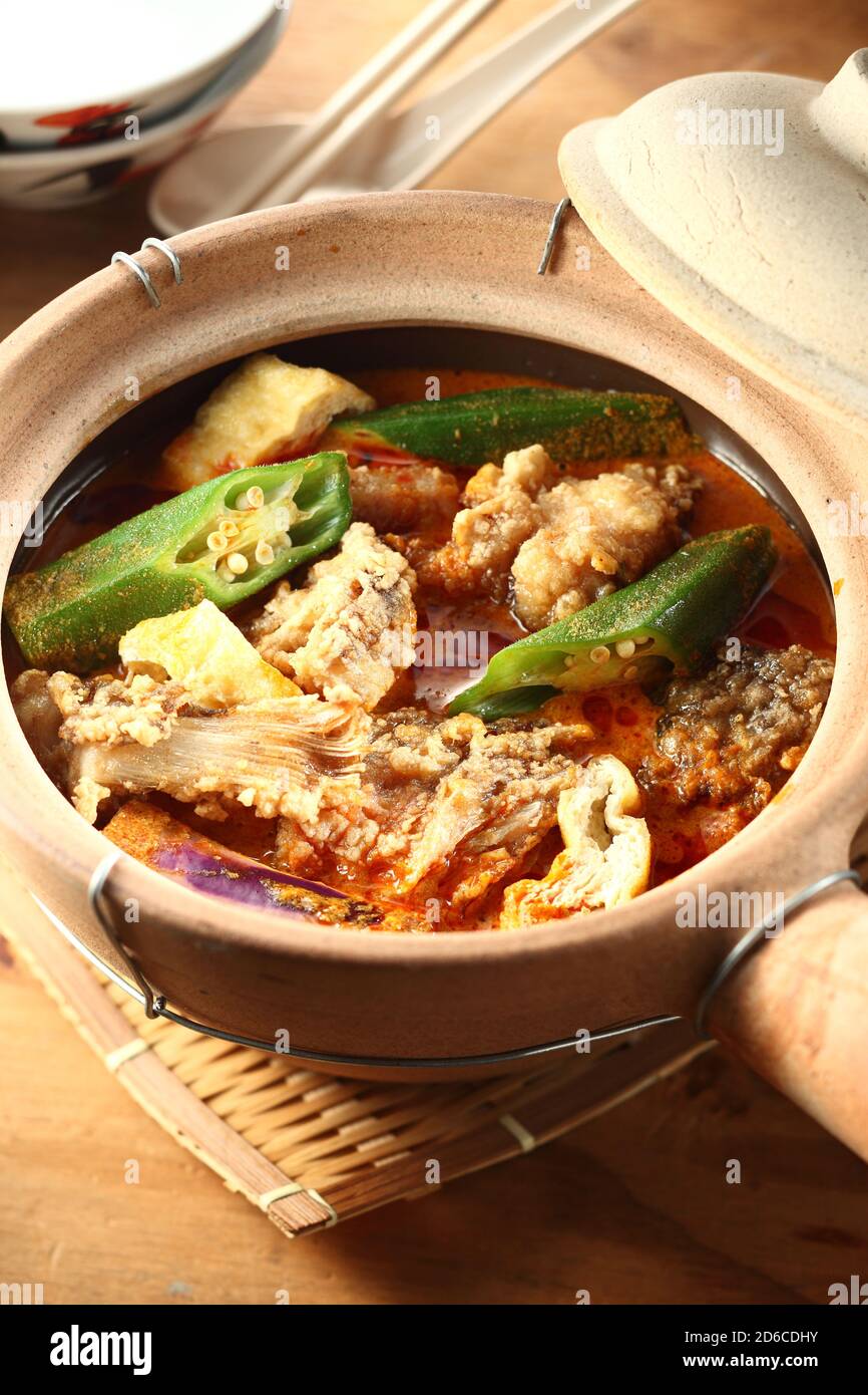 Asian cuisine curry fish head in claypot Stock Photo - Alamy