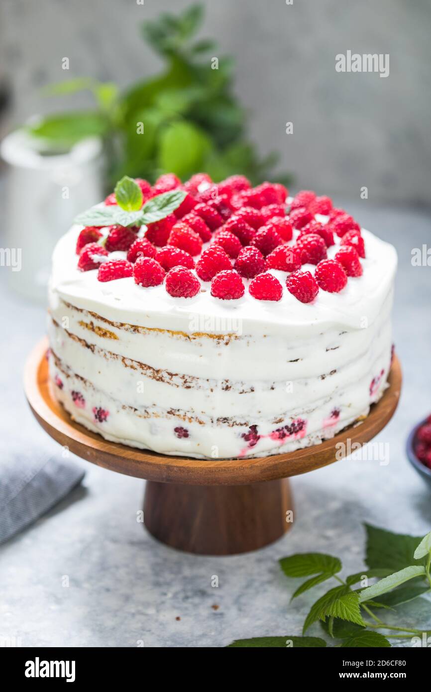 А piece of white cake with milk cream mousse and raspberry filling on a ...