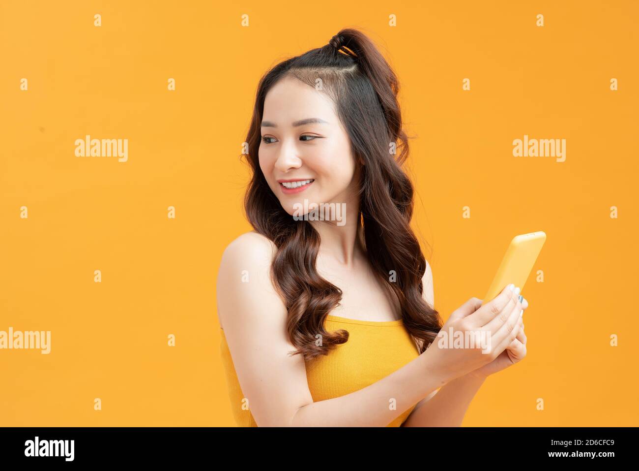 Pretty young woman turning to look back over her shoulder with a happy ...