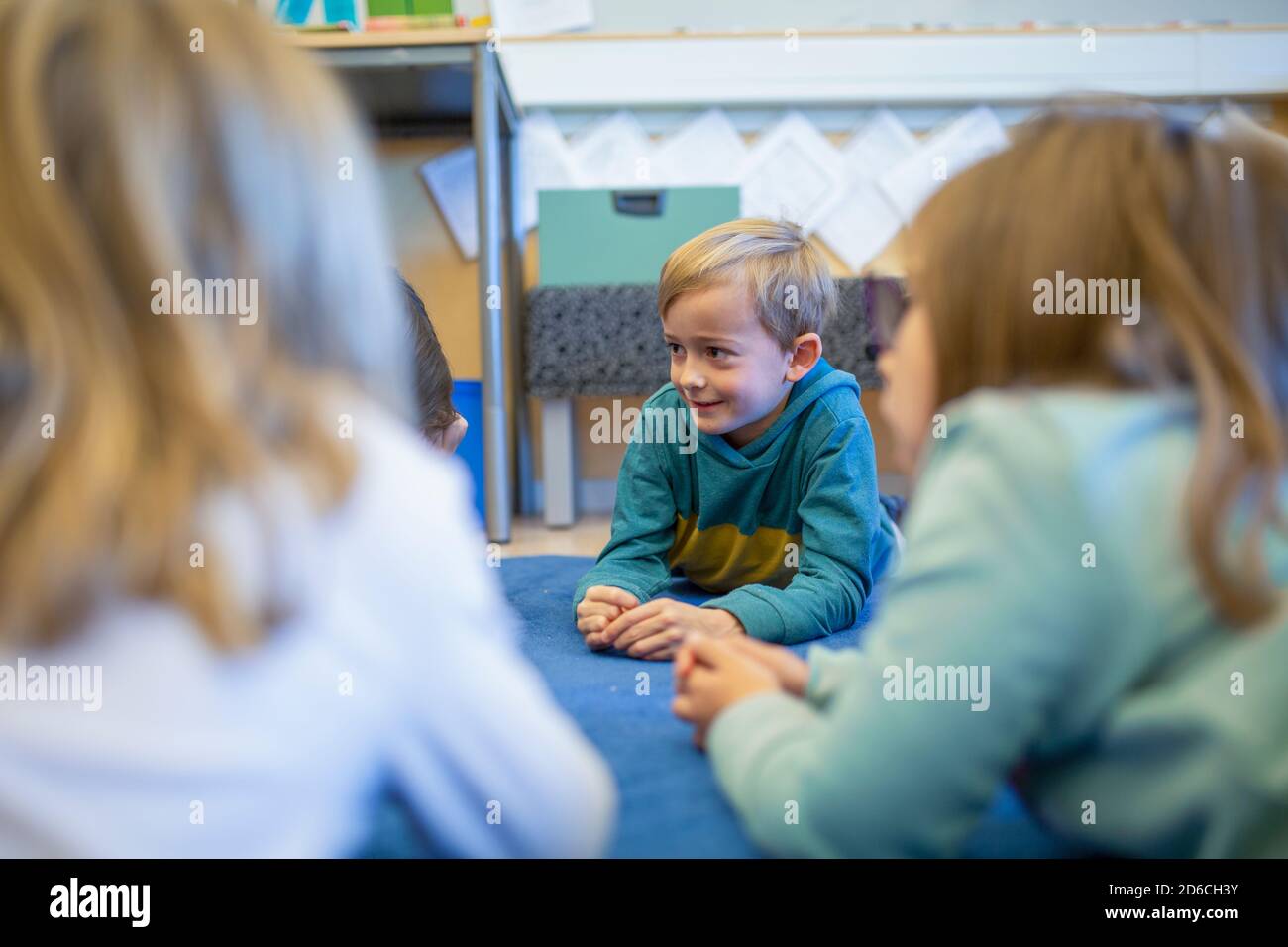 Boy in classroom lying on floor Stock Photo - Alamy